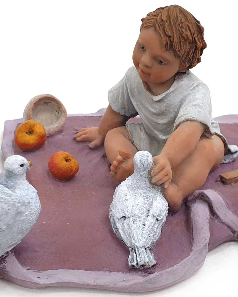 Jesús child playing with pigeons